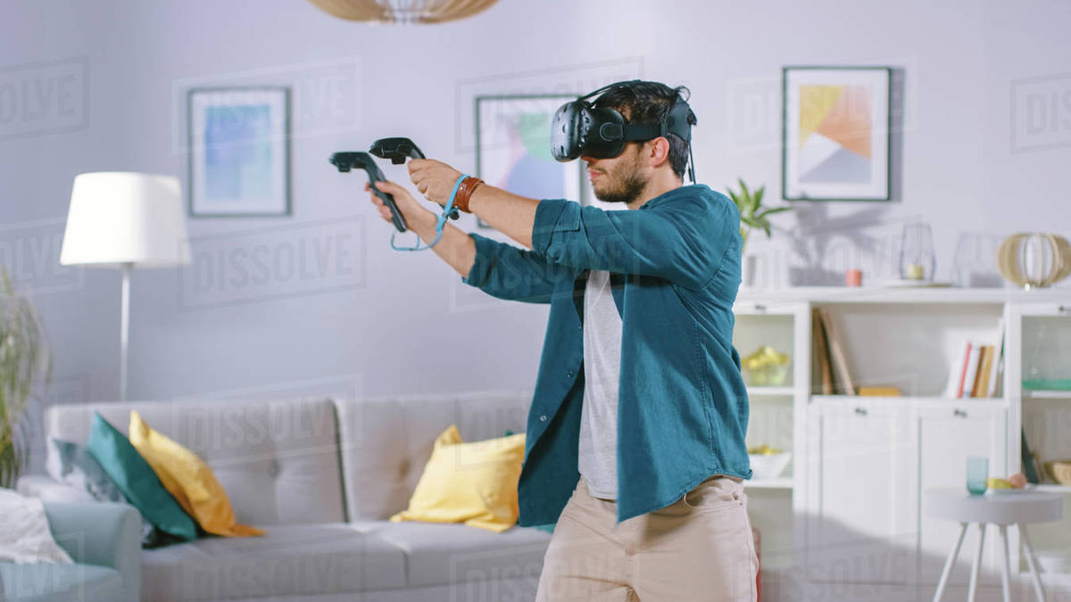 Energetic Young Man Wearing Virtual Reality Headset and Holding ...