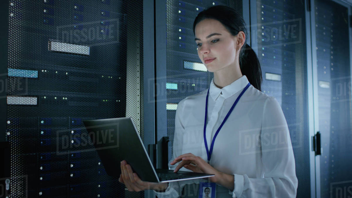 Confident and Beautiful Female IT Engineer is Working on Laptop in Data ...