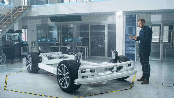 Engineer with Glasses and Beard Scans Electric Car Chassis Prototype ...