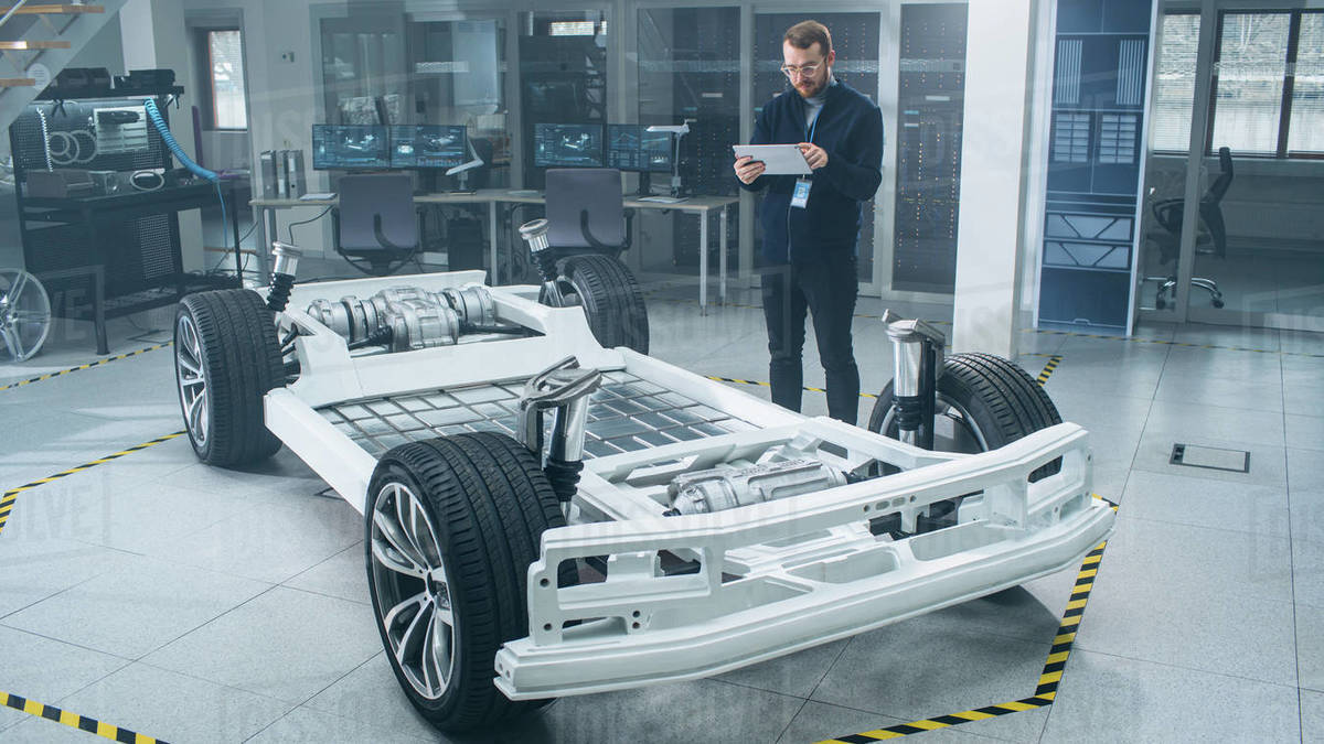 Engineer with Glasses and Beard Scans Electric Car Chassis Prototype ...