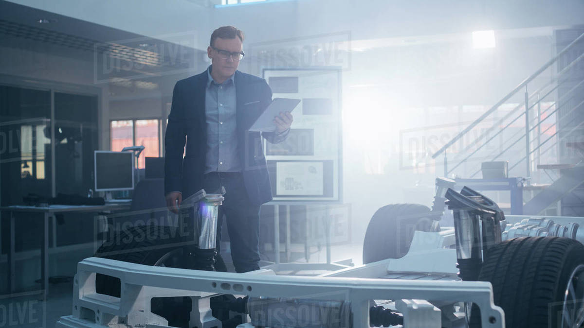Engineer with Glasses Works on a Tablet Computer Next to an Electric ...