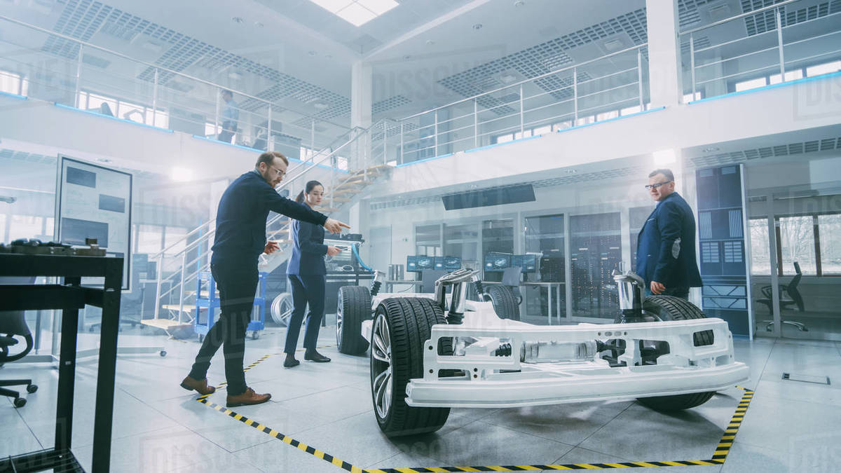 Automotive Design Engineers Talking while Working on Electric Car ...