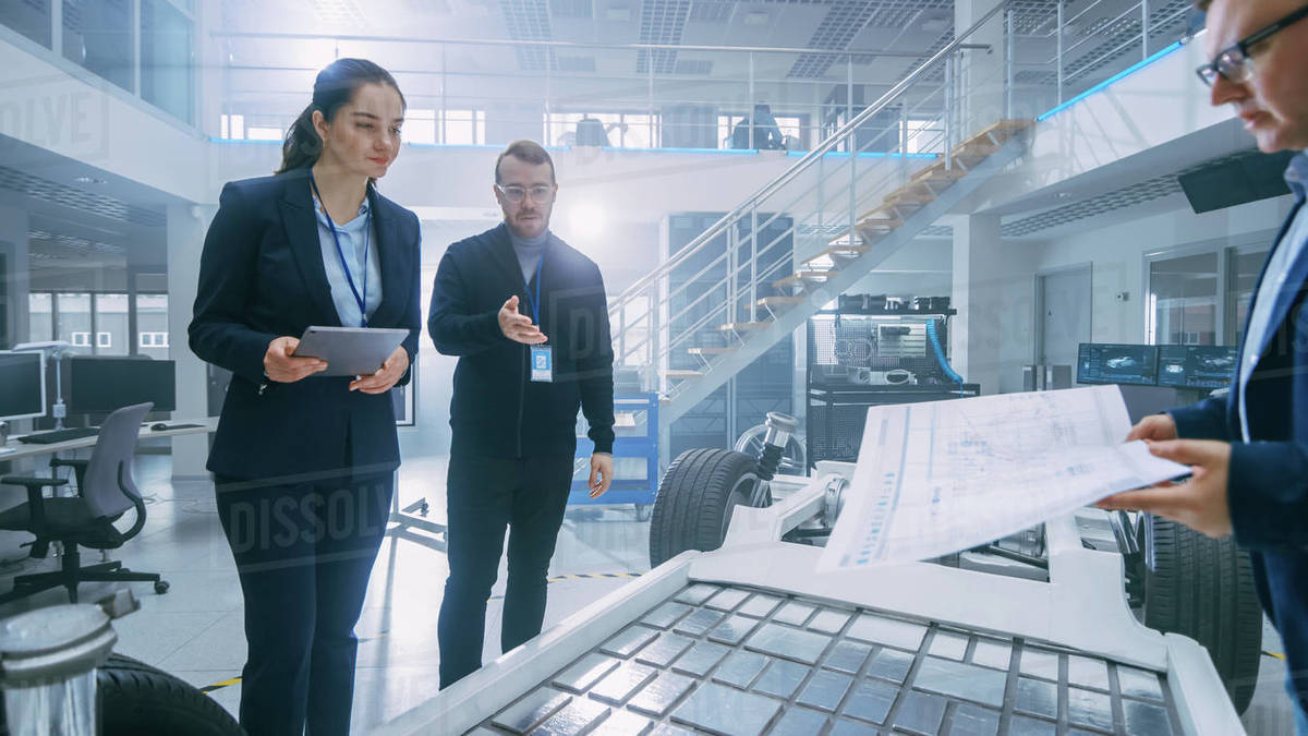 Automotive Design Engineers Talking while Working on Electric Car ...