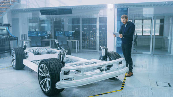 Engineer with Glasses and Beard Scans Electric Car Chassis Prototype ...