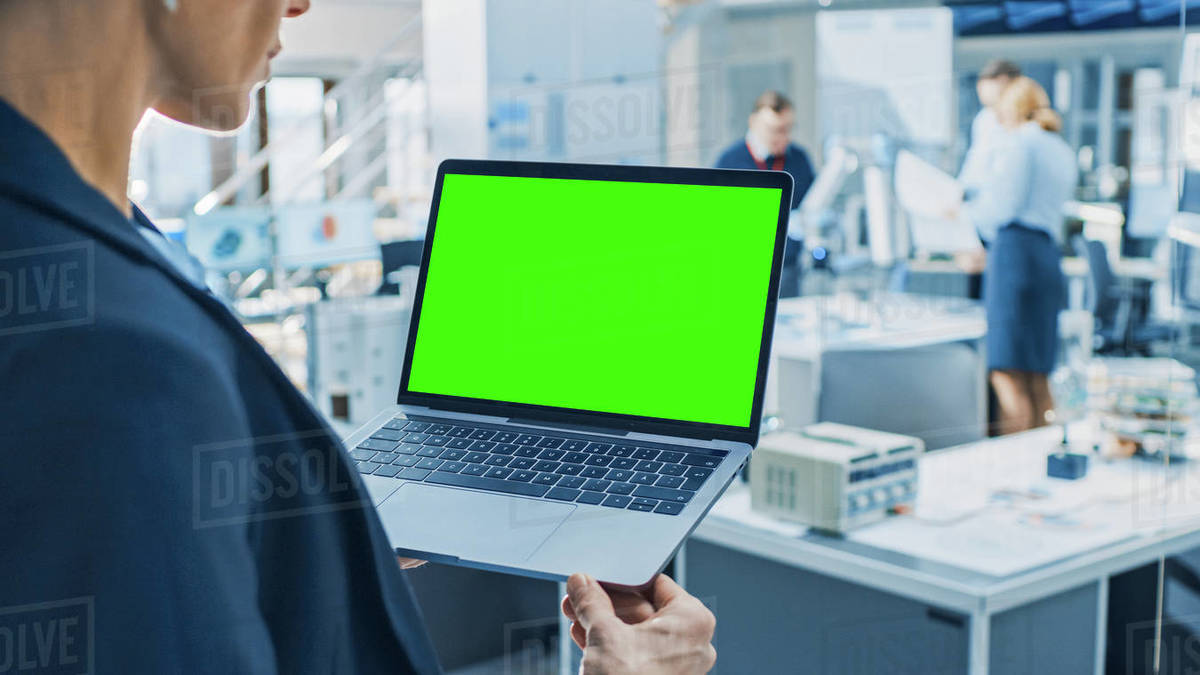 Engineer Holds Green Mock-up Screen Laptop Computer. In the Background ...