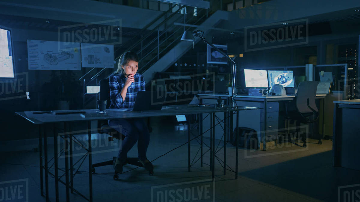Beautiful Female Engineer Sitting at Her Desk Works on a Laptop ...