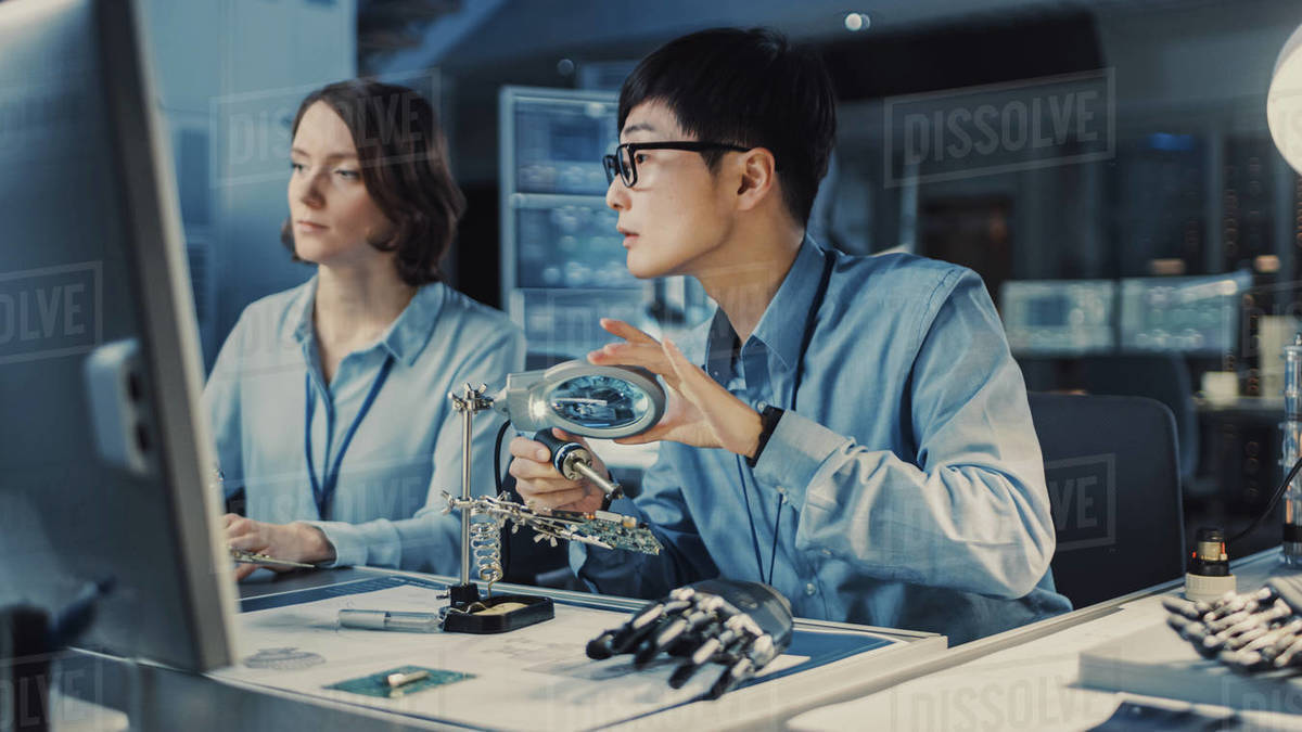 Japanese Development Engineer in Blue Shirt is Soldering a Circuit ...