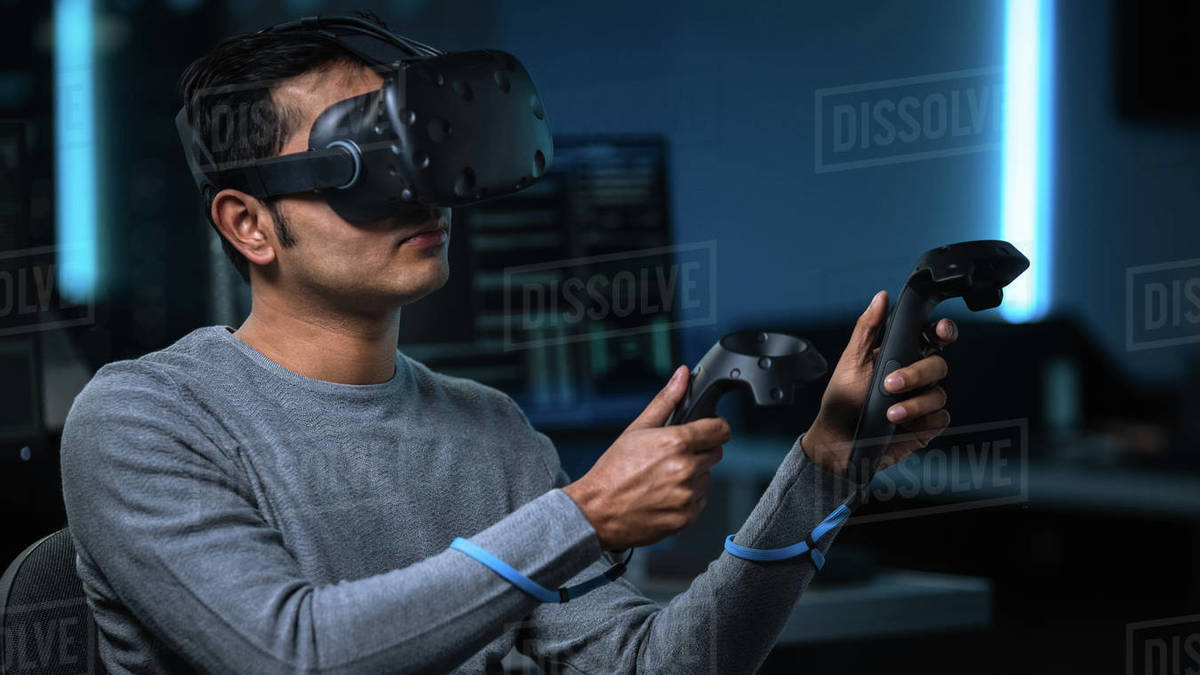 Portrait of Software Delevoper Wearing Virtual Reality Headset Using Controllers to Develop and ...