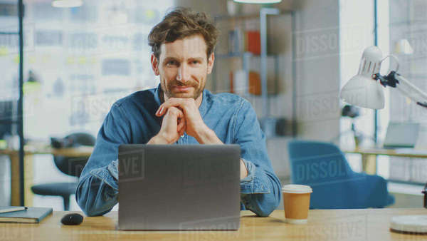 Young Handsome Man Works on a Laptop Computer in Cool Creative Agency ...