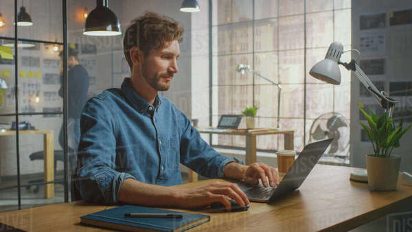 Handsome Creative Male in Jeans Shirt Works on a Laptop in His Sunny ...