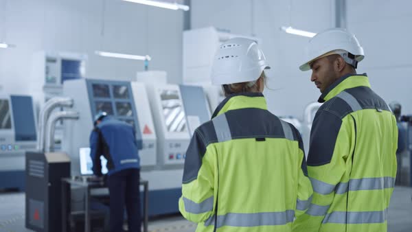 Chief Engineer and Project Manager Wearing Safety Vests, Hard Hats Walk ...