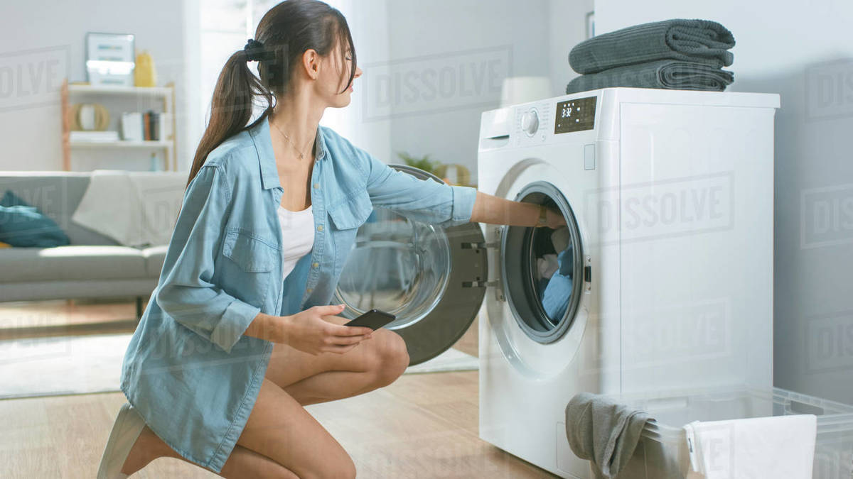 Beautiful Young Woman Sits on Her Knees Next to the Washing Machine ...