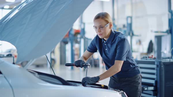 Beautiful Empowering Female Car Mechanic is Working on a Vehicle in a ...