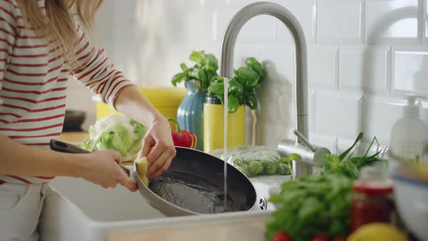 Close Up Footage of a Woman Washing a Frying Pan with a Cleaning Liquid ...