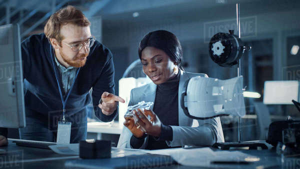 Electronics Development Engineer Working at His Desk, Talks with ...