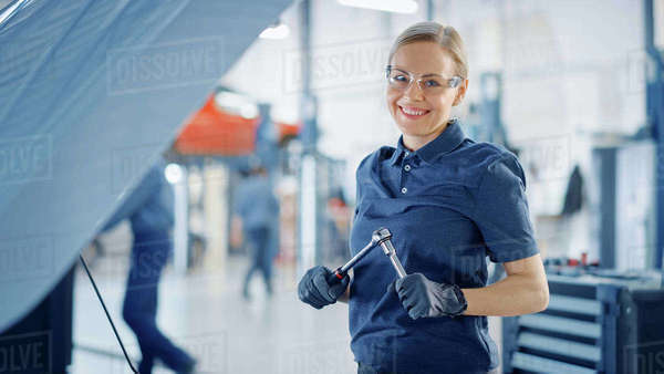Beautiful Empowering Female Car Mechanic is Working on a Vehicle in a ...