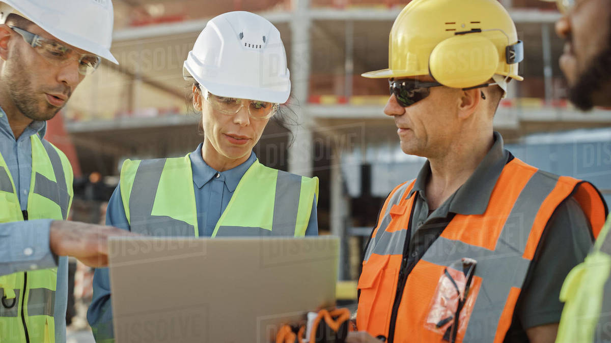 Diverse Team of Specialists Use Laptop Computer on Construction Site ...