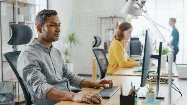 Smart and Handsome Indian Office Worker Sitting at His Desk works on a ...