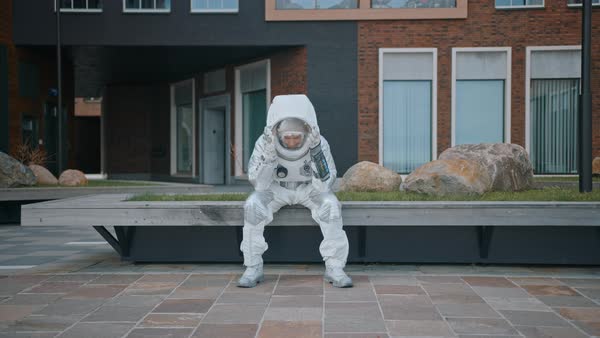 Sad Man in Spacesuit is Sitting on Wooden Bench. Miserable Astronaut ...