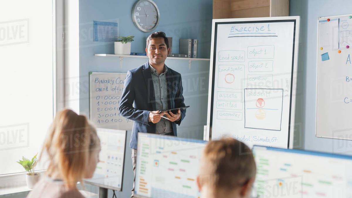 Elementary School Class: Teacher Uses Interactive Digital Whiteboard, Explains Lesson to Diverse ...