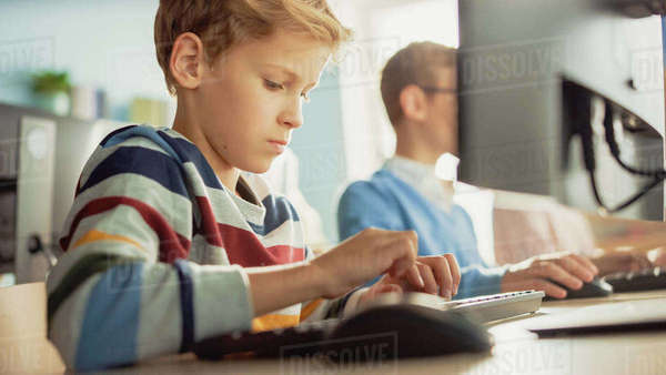 Elementary School Computer Science Classroom: Smart Little Boy Uses ...