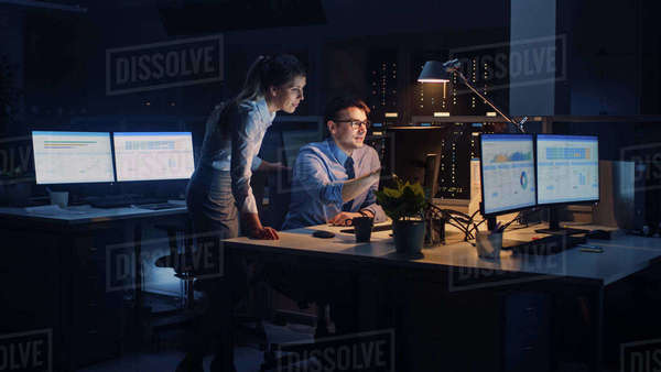 Ambitious and Confident Businessman Uses Desktop Computer, His Female ...