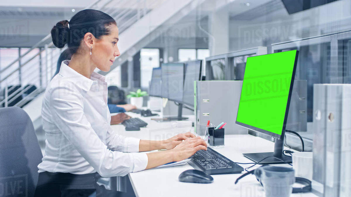 Young Handsome Female Manager Works on a Desktop Computer with Green ...