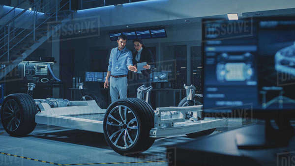 Auto Industry Design Facility: Male Chief Engineer Shows Car Prototype ...