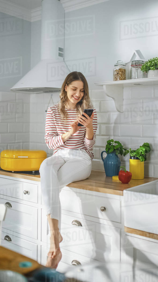 Beautiful Young Female in Striped Jumper and White Pants is Sitting on ...