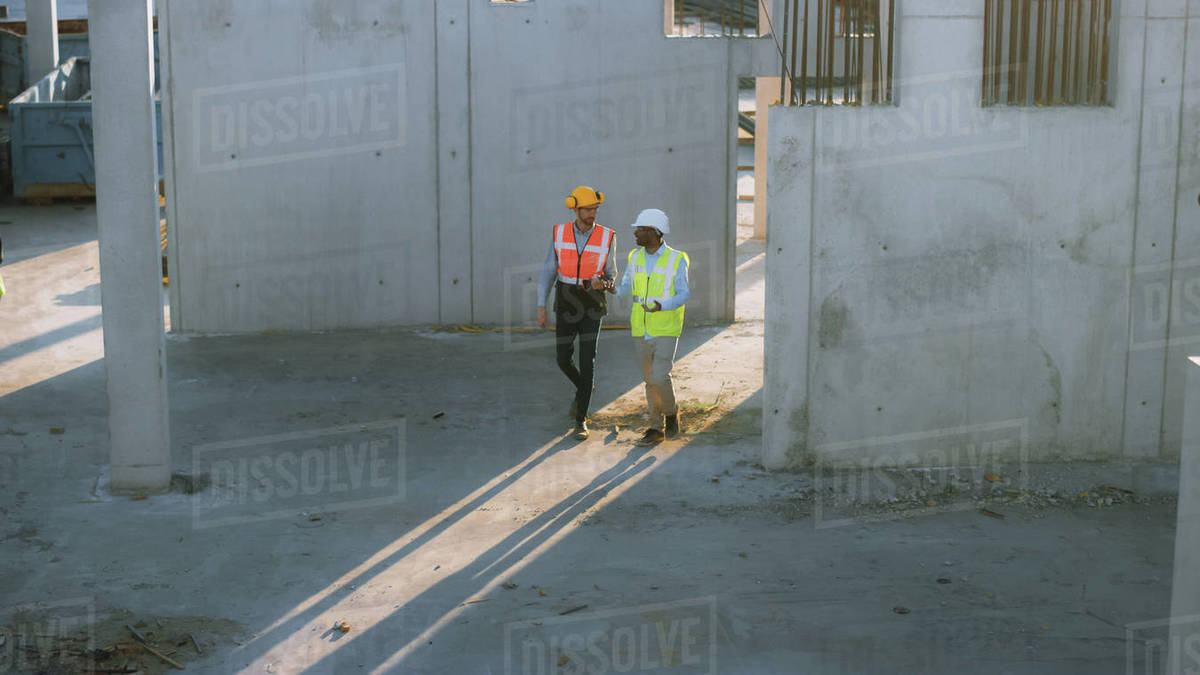 Two Multicultural General Contractors Taking a Walk Through ...