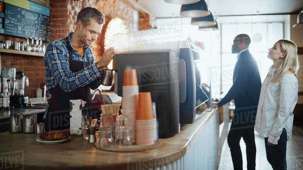 Barista making customer coffee orders in a local coffee shop - Royalty ...