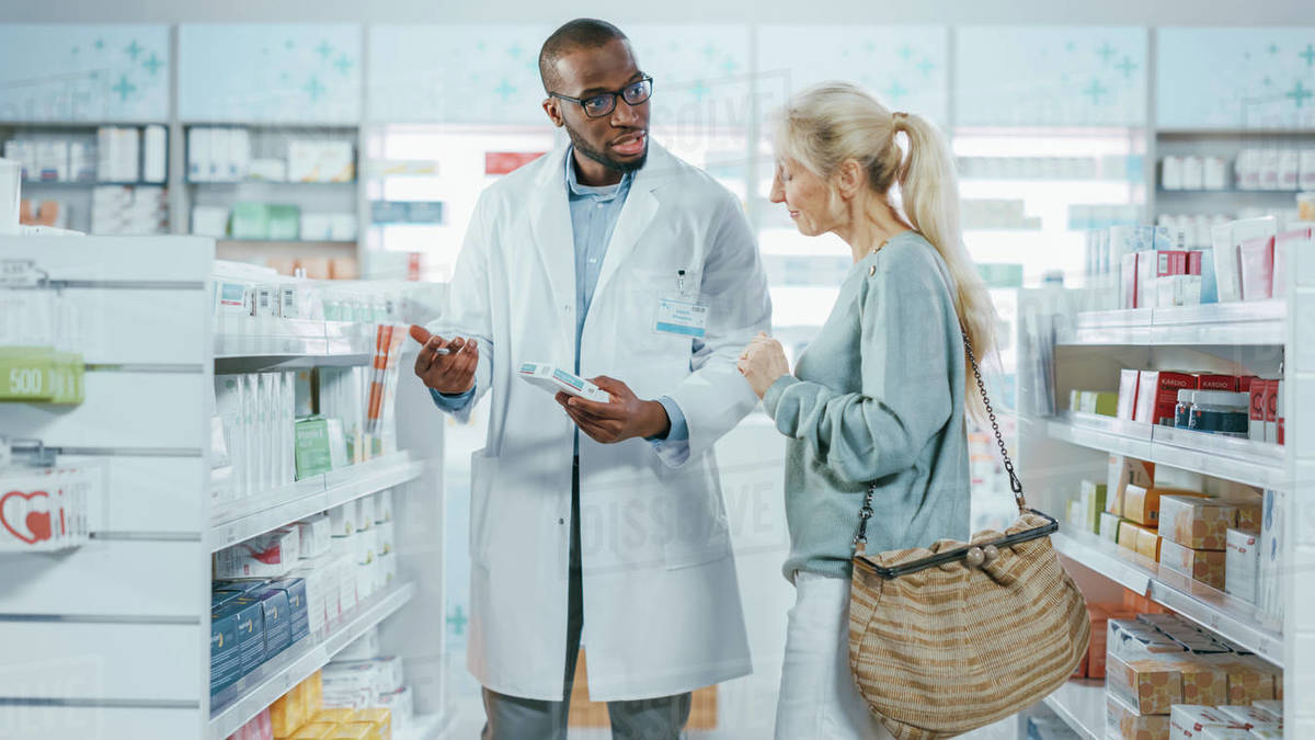 Professional Black Helpful Pharmacist Advising Caucasian Senior Female ...