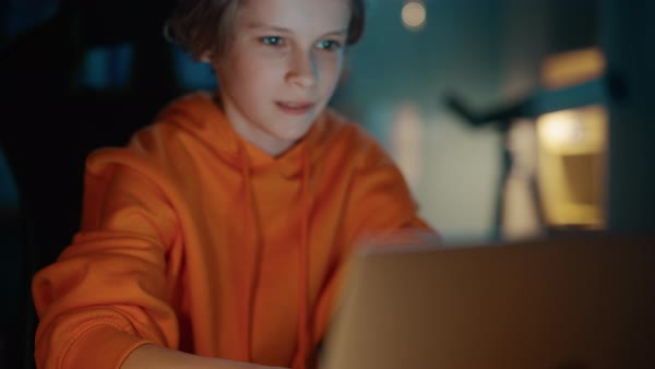 Close Up Portrait of a Smart Young Boy Using Laptop Computer in Cozy ...