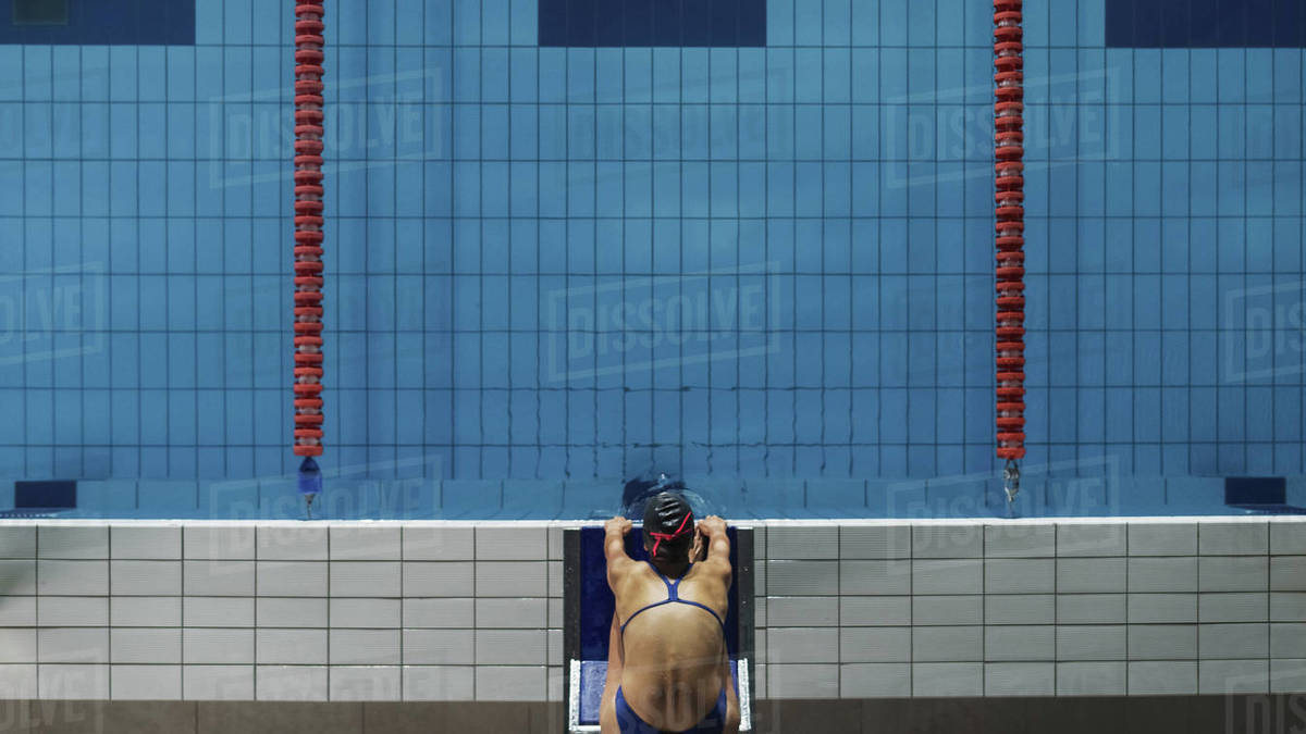 Aerial Top View Female Swimmer Standing on a Starting Block, Ready to ...