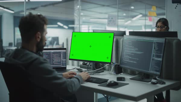 IT Programmer Working on Computer with Green Screen Chroma Key Display ...