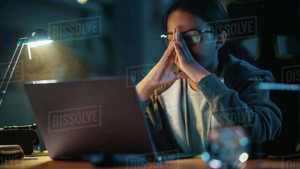 Concentrated Young Teenage Black Girl Using Laptop Computer in a Dark ...