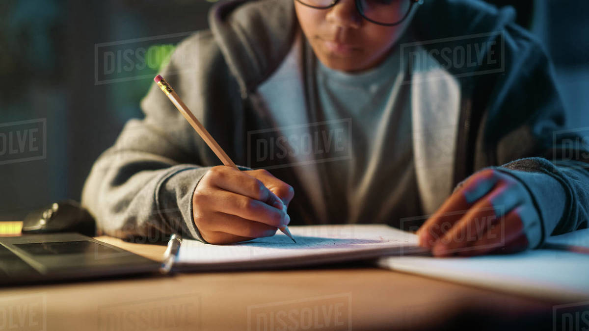Young Teenage Black Girl Writing Down Homework in a Notebook with a ...