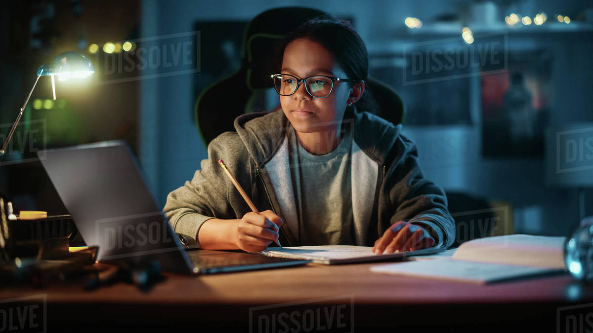 Young Teenage Girl Writing Down Homework in a Notebook with a Pencil ...