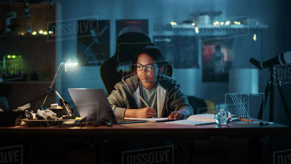 Young Teenage Girl Writing Down Homework in a Notebook with a Pencil ...