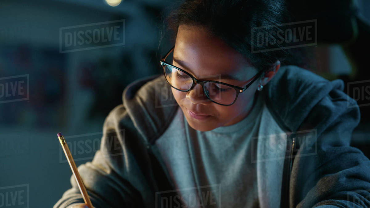 Young Teenage Black Girl Writing Down Homework in a Notebook with a ...