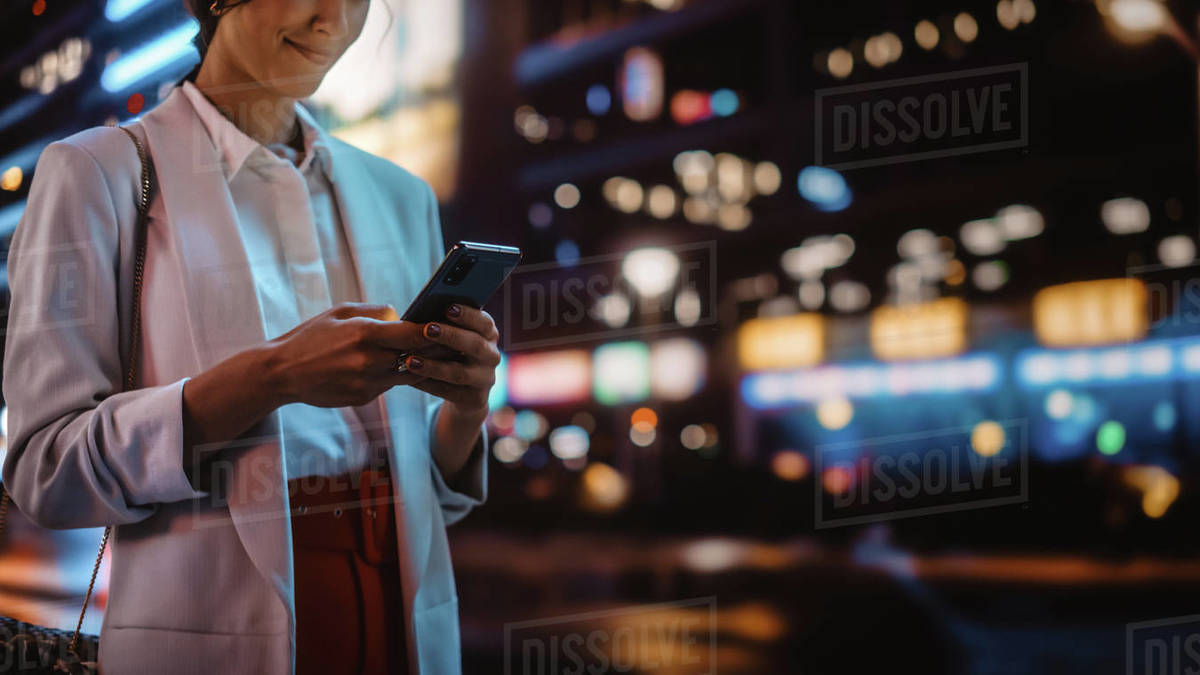 Anonymous Female Using Smartphone Walking Through Night City Street ...