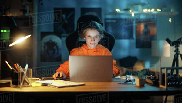 Young Boy Using Laptop Computer in a Dark Cozy Room at Home - Royalty ...