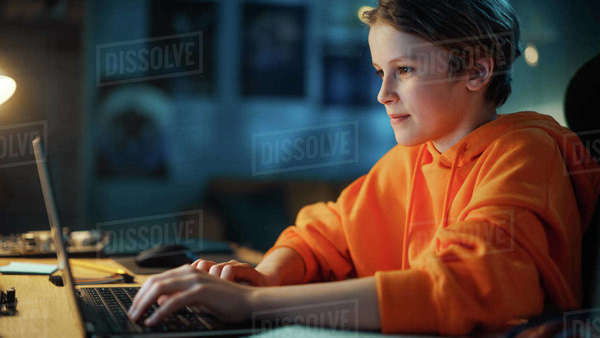 Young Boy Using Laptop Computer in a Dark Cozy Room at Home - Royalty ...