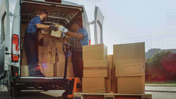 Two Workers use Hand Pallet Truck Loading Delivery Truck with Cardboard ...