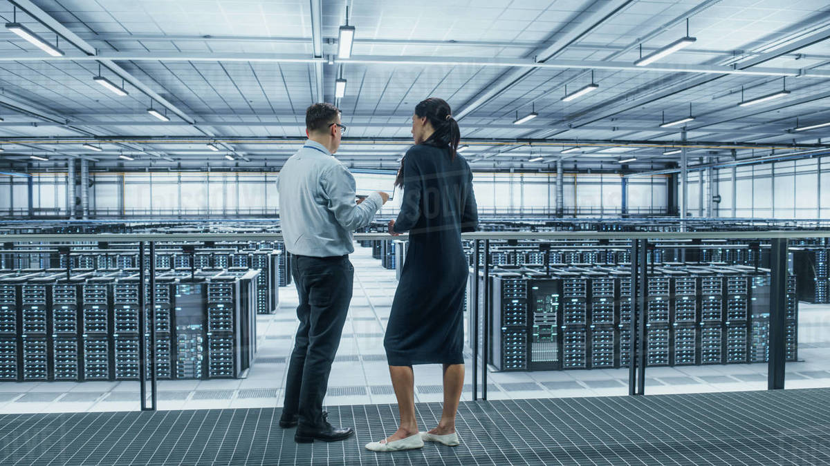 Data Center Female System Administrator and Male IT Specialist Talk ...