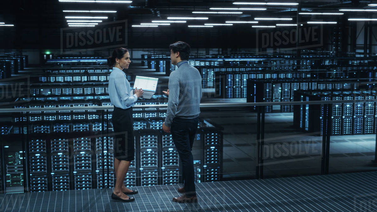 Data Center Female System Administrator and Male IT Specialist Talk ...