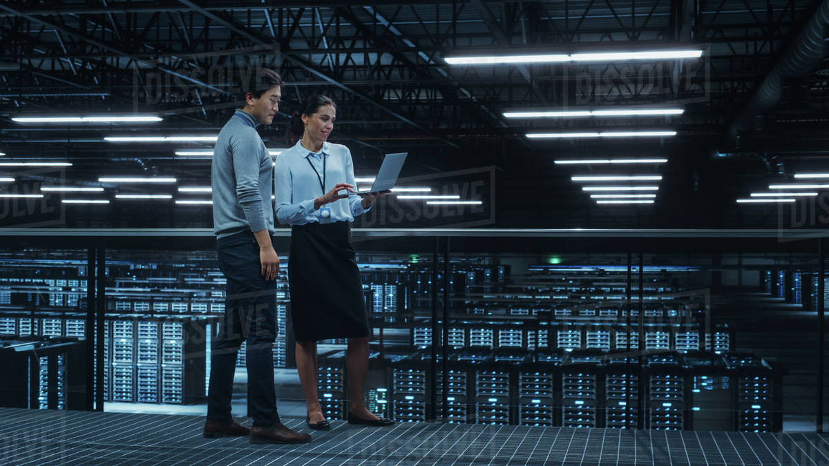 Data Center Female System Administrator and Male IT Specialist Talk ...