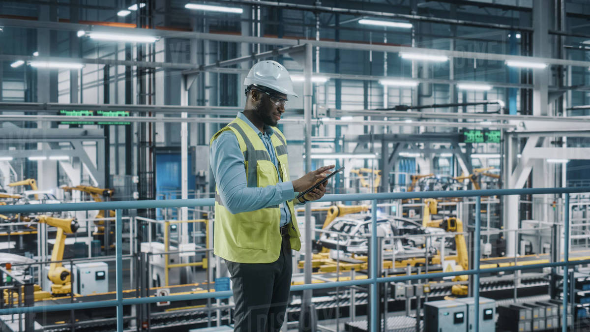 African American Car Factory Engineer in High Visibility Vest Using ...