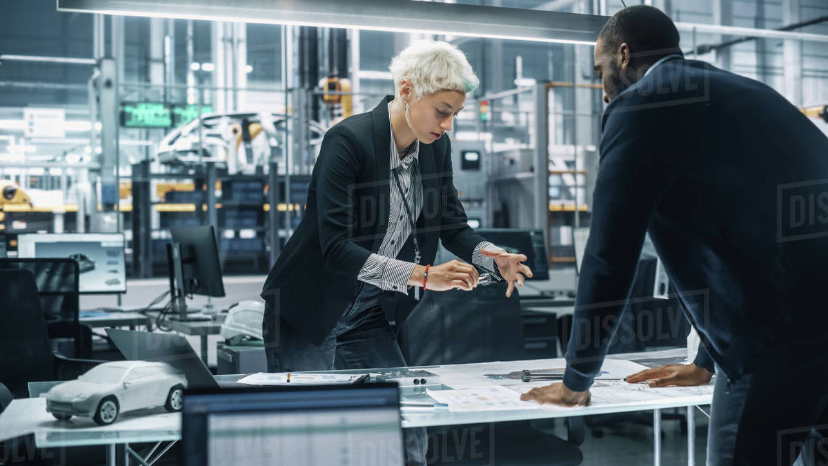 Two Young Automotive Engineers Working in Office at Car Factory ...
