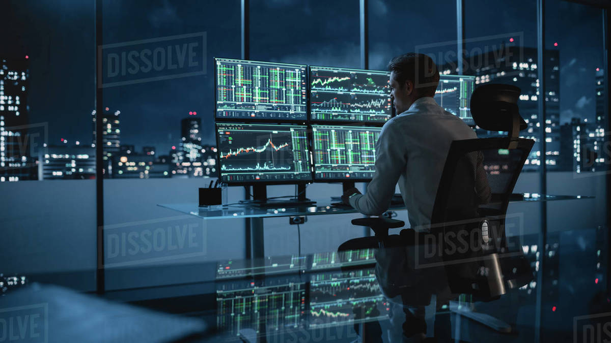 Financial Analyst Working on a Computer with Multi-Monitor Workstation with Real-Time Stocks ...
